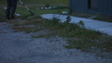 Young Person Weed Whacking Front Of Comm... | Stock Video | Pond5