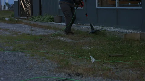 Young Person Weed Whacking Front Of Comm... | Stock Video | Pond5