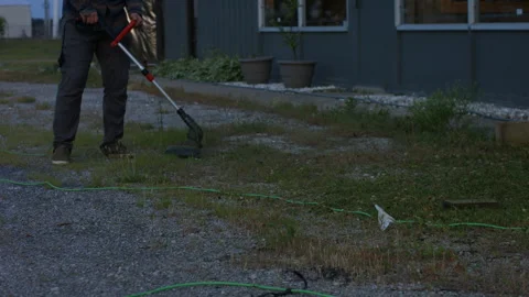 Young Person Weed Whacking Front Of Comm... | Stock Video | Pond5