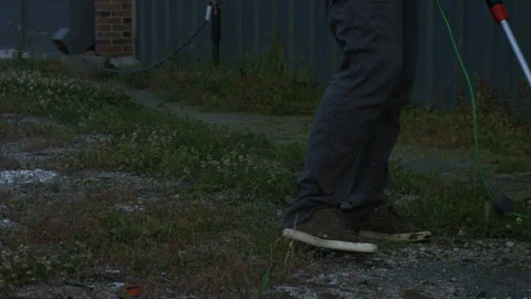 Young Person Weed Whacking Front Of Comm... | Stock Video | Pond5