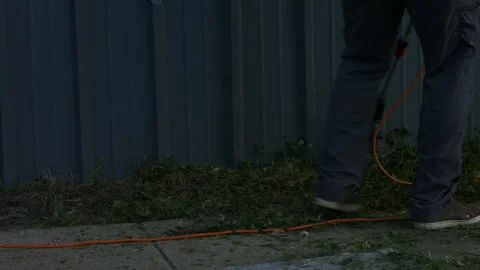 Young Person Weed Whacking Front Of Comm... | Stock Video | Pond5
