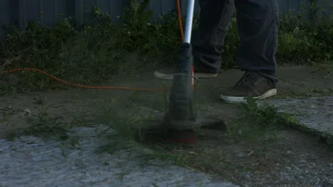 Young Person Weed Whacking Front Of Comm... | Stock Video | Pond5