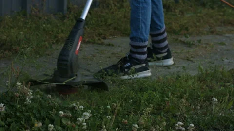 Young Person Weed Whacking Front Of Comm... | Stock Video | Pond5