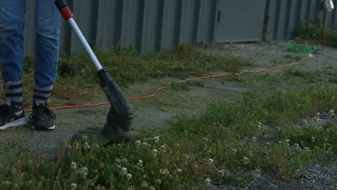 Young Person Weed Whacking Front Of Comm... | Stock Video | Pond5