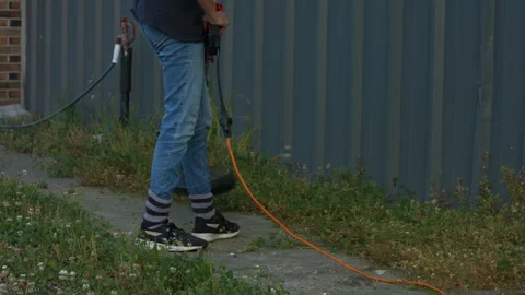 Young Person Weed Whacking Front Of Comm... | Stock Video | Pond5