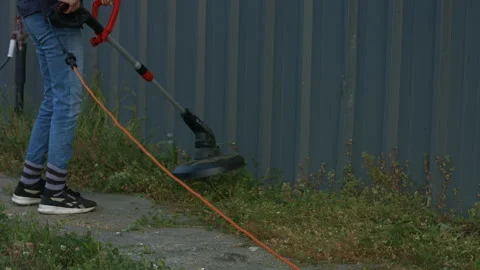 Young Person Weed Whacking Front Of Comm... | Stock Video | Pond5