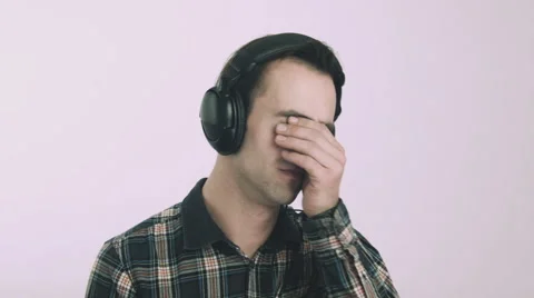 Young sad man listening to music on head... | Stock Video | Pond5