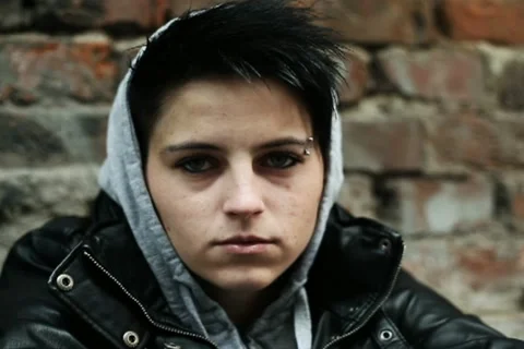 Young sad punk girl sitting by the wall,... | Stock Video | Pond5