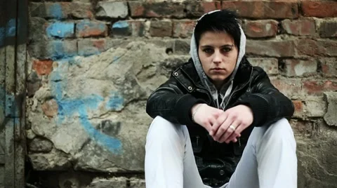 Young sad punk girl sitting by the brick... | Stock Video | Pond5