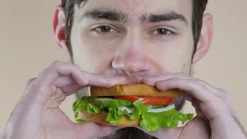 Young slender guy eating junk food. The ... | Stock Video | Pond5