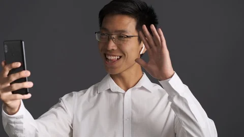 Young smiling asian man in eyeglasses ha... | Stock Video | Pond5