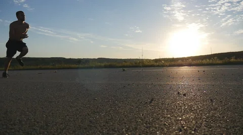 Young strong man running on road in beau... | Stock Video | Pond5