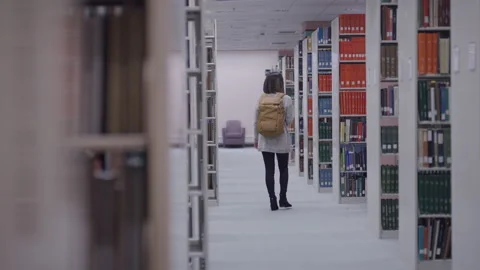 Young Student Wanders Through a Library | Stock Video | Pond5
