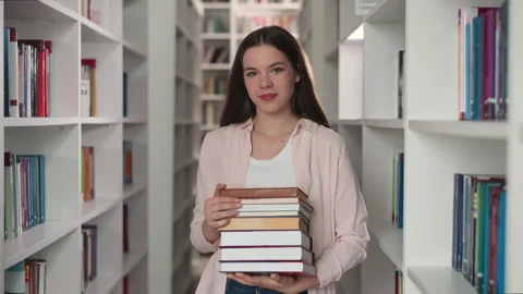 Young teacher with folio stack in librar... | Stock Video | Pond5
