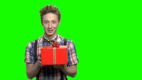 Young teen boy presenting gift box. | Stock Video | Pond5