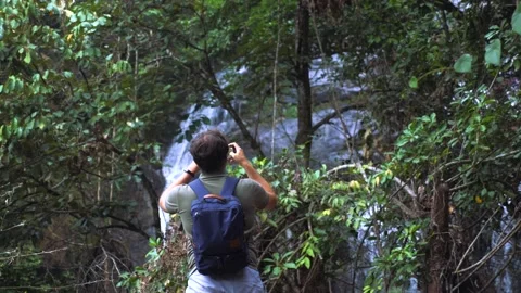 Young travel man walking on waterfall an... | Stock Video | Pond5