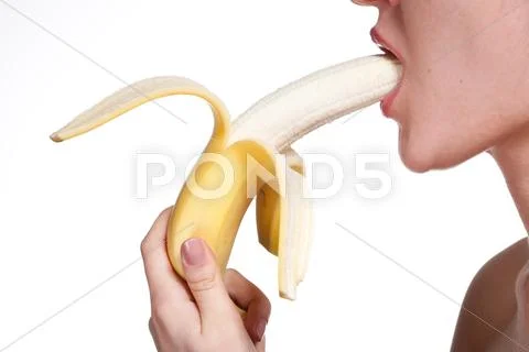 Young woman biting banana isolated on white ~ Hi Res #31339148