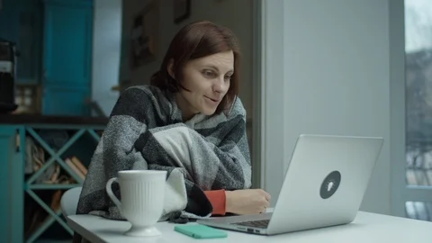 Young woman in blanket sitting at desk a... | Stock Video | Pond5