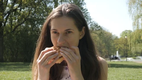 Young Woman Brunette eating Sandwich Bur... | Stock Video | Pond5