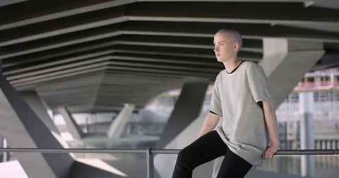 Young woman with buzz cut sitting on rai... | Stock Video | Pond5