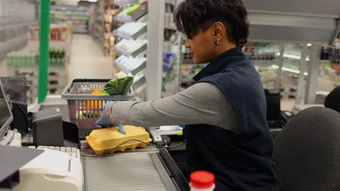 Young woman cashier scanning goods and w... | Stock Video | Pond5