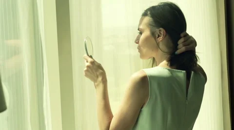 Young woman checking her appearance in m... | Stock Video | Pond5