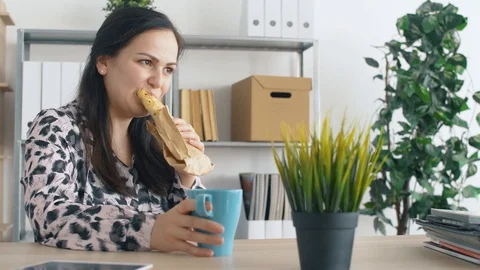 Young woman eating fast food in office. ... | Stock Video | Pond5