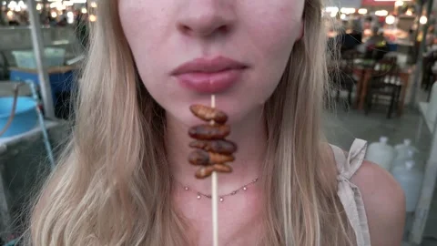 Young woman eats fried insects at a nigh... | Stock Video | Pond5