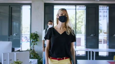 Young woman with face masks back at work... | Stock Video | Pond5