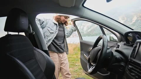 A young woman getting into a car and sta... | Stock Video | Pond5