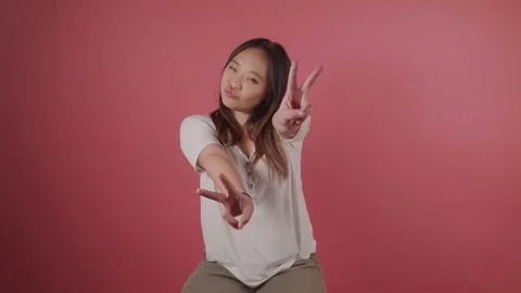 Young Woman Giving Double Peace Sign | Stock Video | Pond5