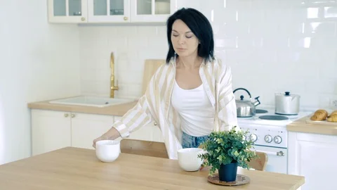 Young woman laying the table for breakfa... | Stock Video | Pond5