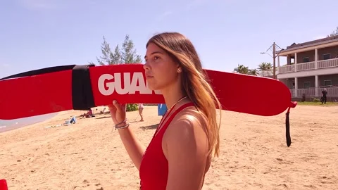 Young Woman Lifeguard at Beach Walking w... | Stock Video | Pond5