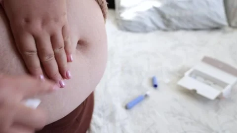 A young woman preperes her belly for inj... | Stock Video | Pond5