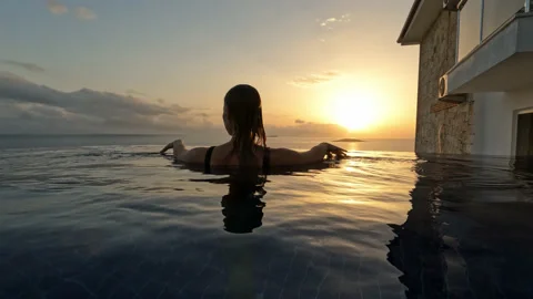 young woman at sunset in infinity pool o... | Stock Video | Pond5
