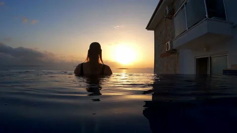 young woman at sunset in infinity pool o... | Stock Video | Pond5