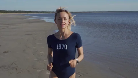 Young woman in swimsuit running on sea b... | Stock Video | Pond5