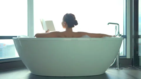 Young woman takes bath sitting in bathtu... | Stock Video | Pond5
