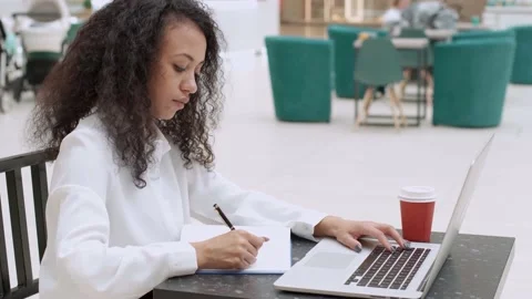 young woman taking notes in a notebook w... | Stock Video | Pond5