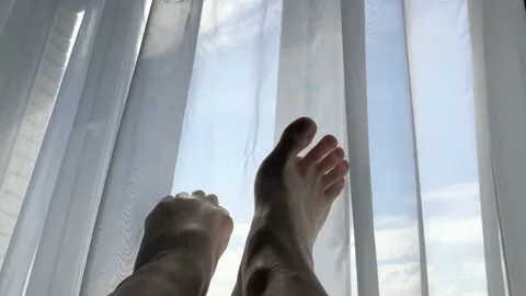 Young woman wiggling bare feet against b... | Stock Video | Pond5