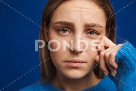 Young woman wiping her tears while crying Stock Photo #225307540