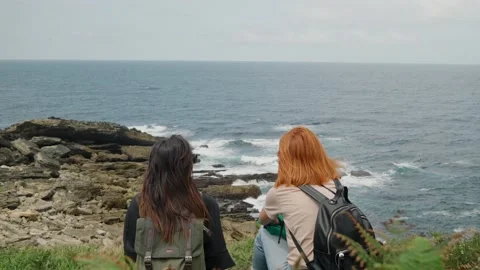 Young women sit on grass watching raging... | Stock Video | Pond5