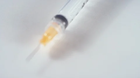 Zoom in to a needle of a syringe on a wh... | Stock Video | Pond5