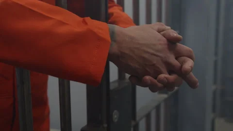 Zoom out from black inmate hands in a ja... | Stock Video | Pond5