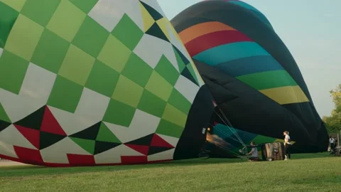 Zoom out on hot air ballons being filled... | Stock Video | Pond5